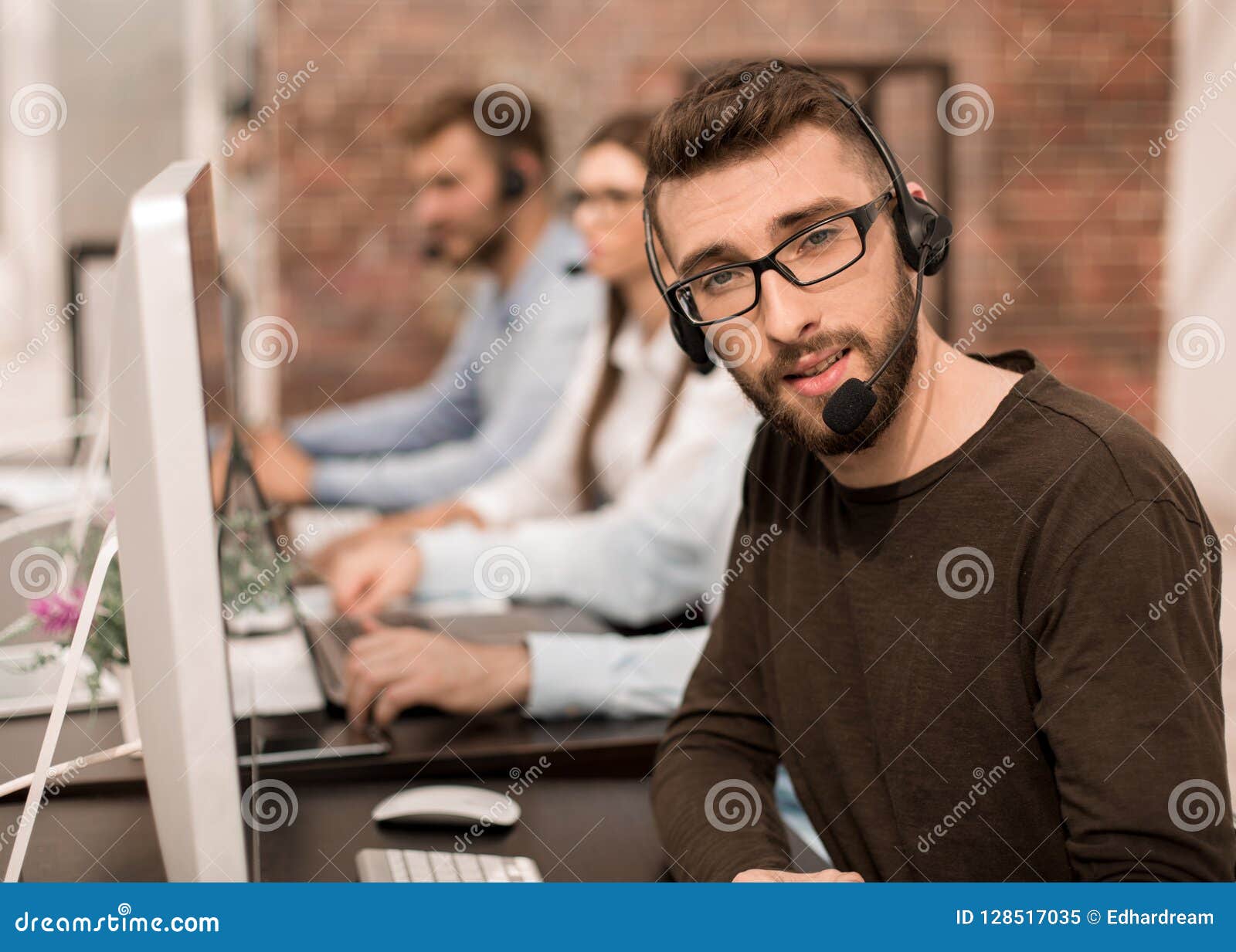 Man with Headset Sitting by Computers in a Bright Office Stock Image ...