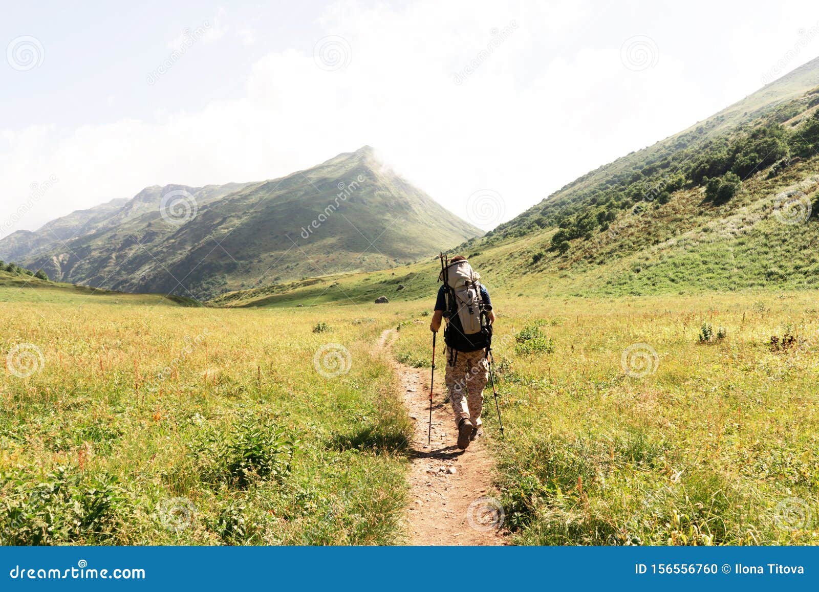 Man with a Heavy Backpack Walks on a Trail in the Mountains Stock Photo ...