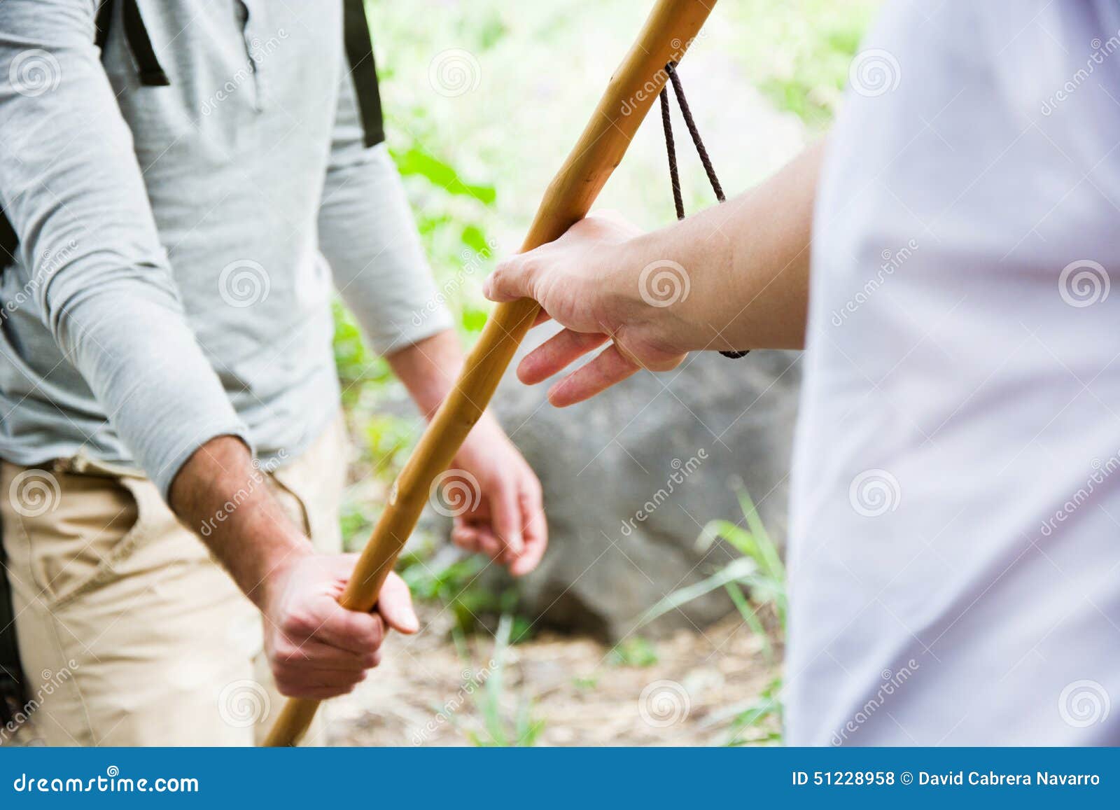 Man Helping Another Giving a Stick for Hiking Stock Photo - Image of ...