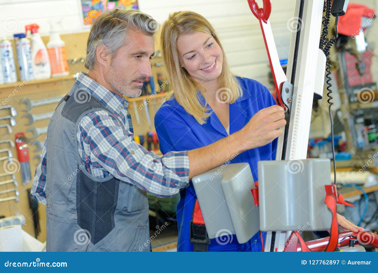 Man Helping Lady with Hoist Stock Image - Image of smile, workshop ...