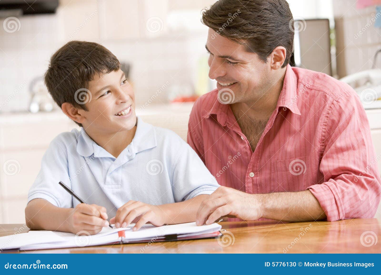 Man Helping Young Boy in Kitchen Doing Homework an Stock Photo - Image ...