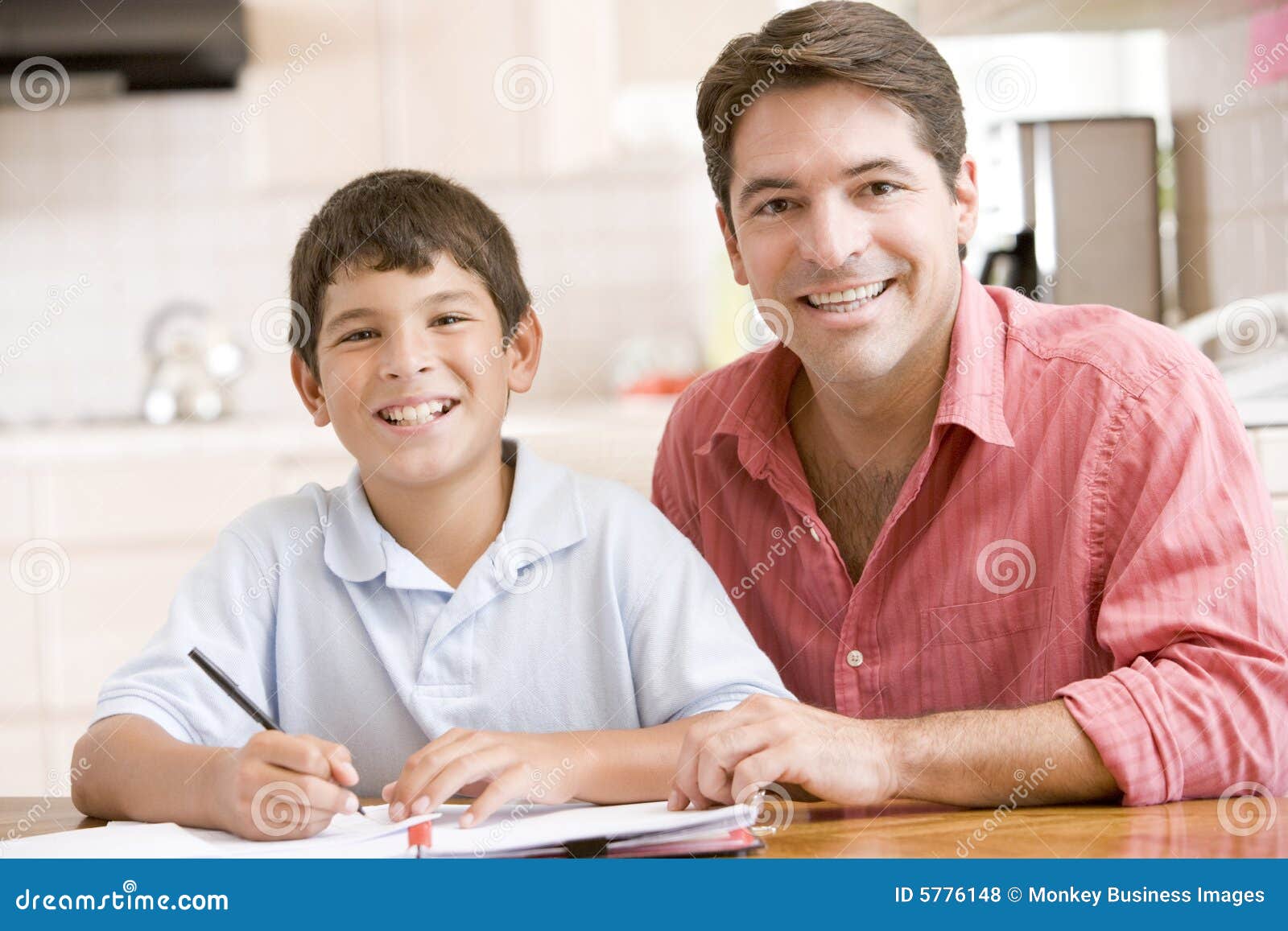 Man Helping Young Boy in Kitchen Doing Homework an Stock Photo - Image ...