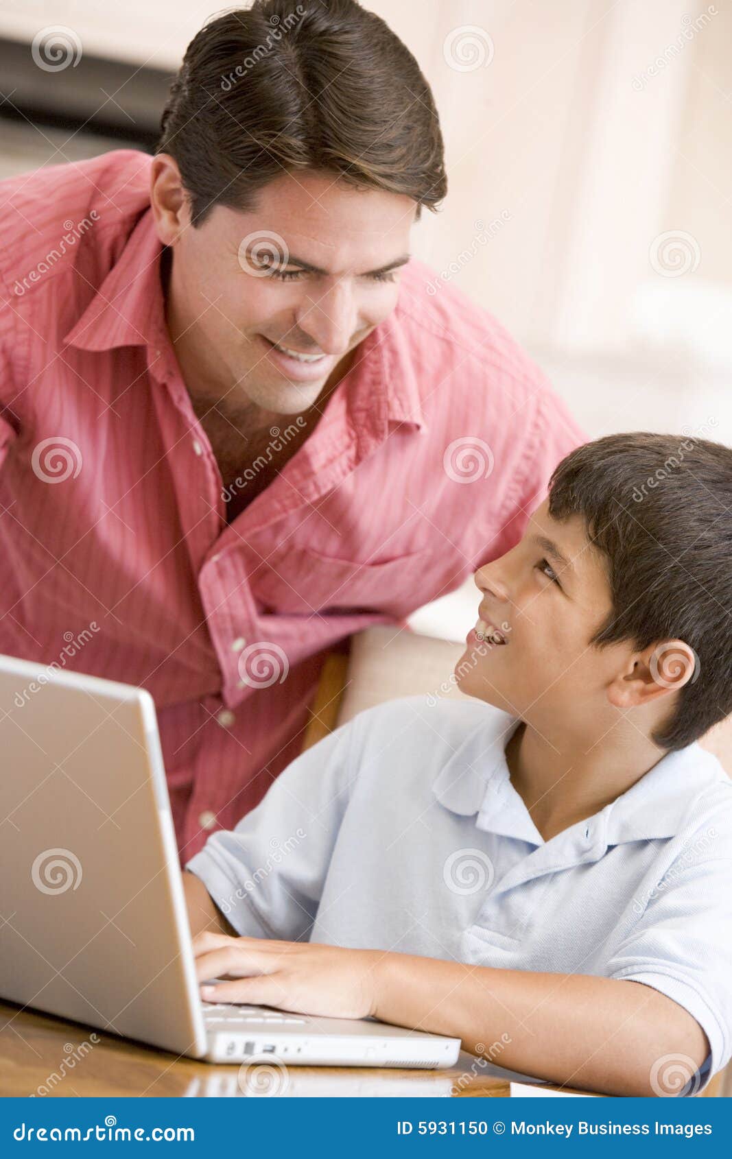 Man Helping Young Boy in Kitchen with Laptop Stock Photo - Image of ...