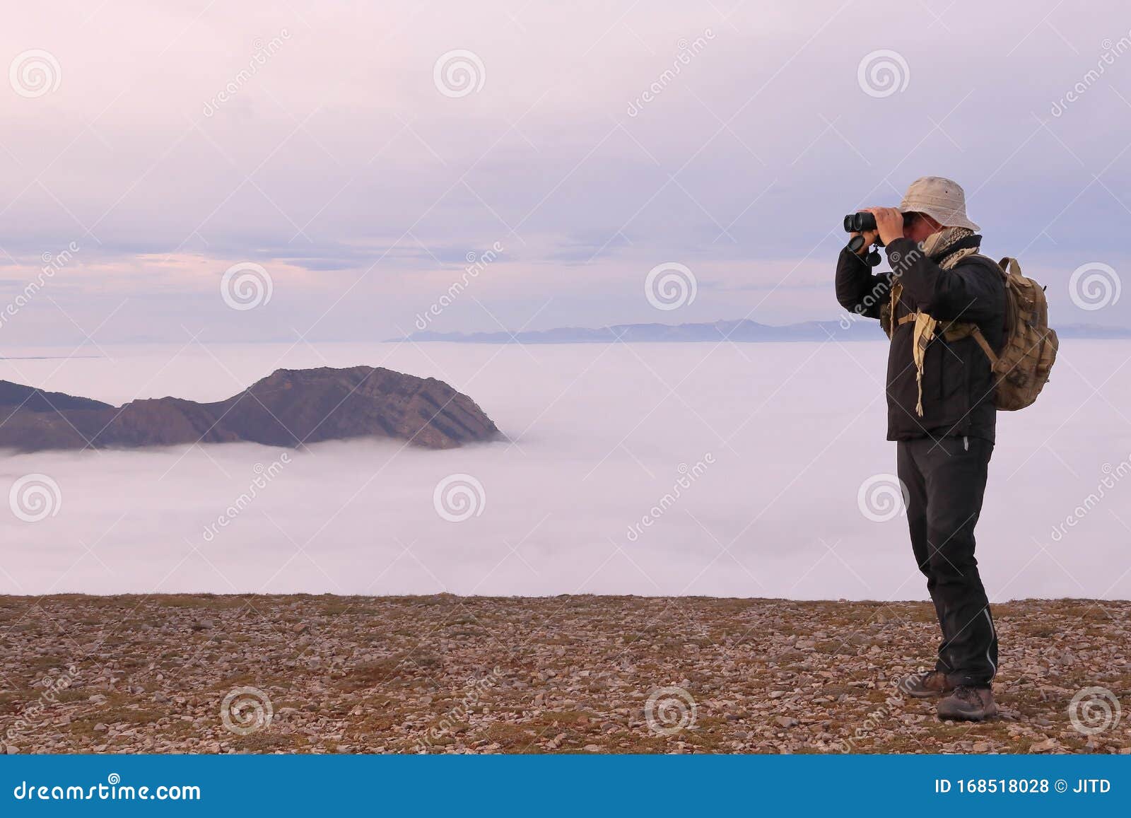 ADVENTURER MAN with a HAT and BACKPACK LOOKING through BINOCULARS NEXT ...