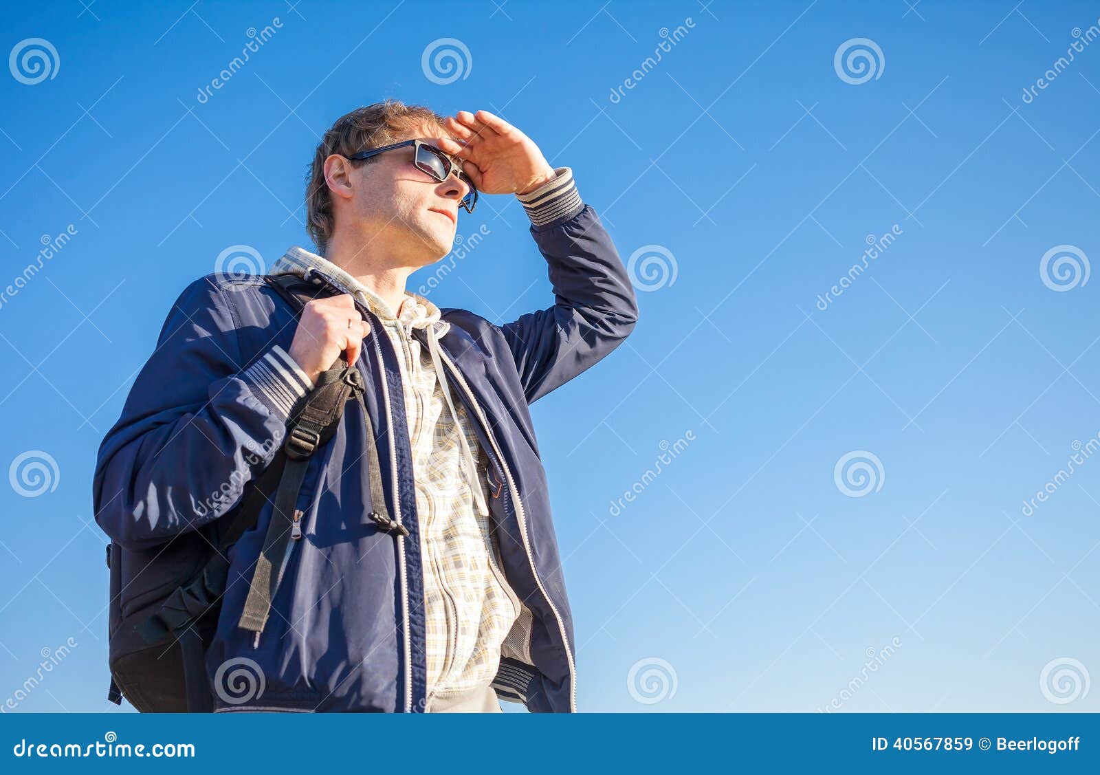 Man Hiker Holding Backpack on a Sunny Day Against a Blue Sky Stock ...