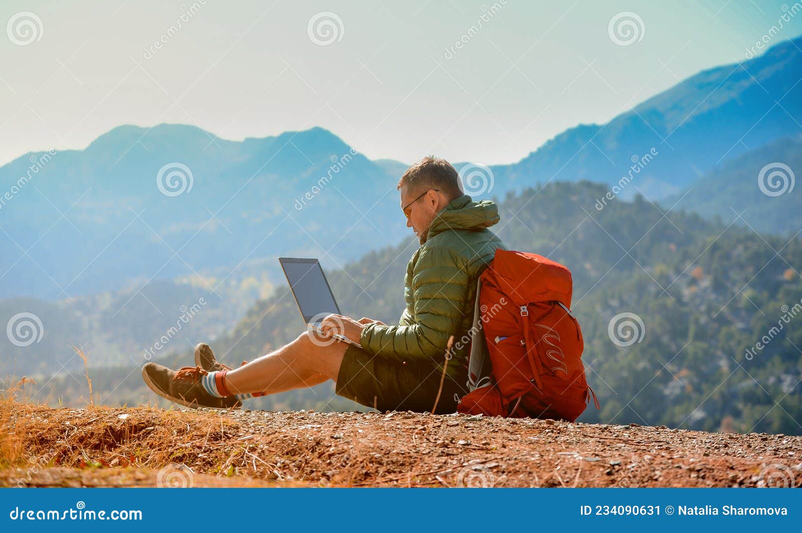 Man Hiker Using a Laptop Working on Top of Mountains. Remote Work with ...