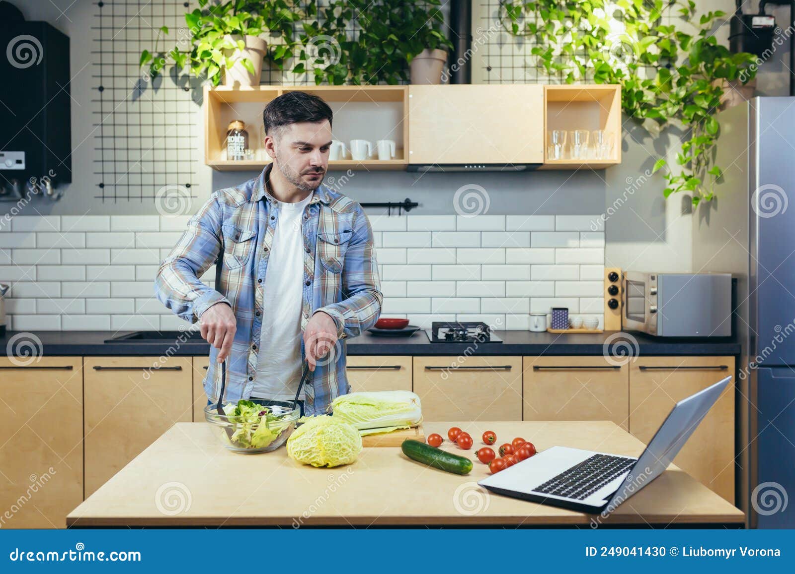 The Man Himself Cooks Vegetables in the Kitchen, Uses a Laptop for ...