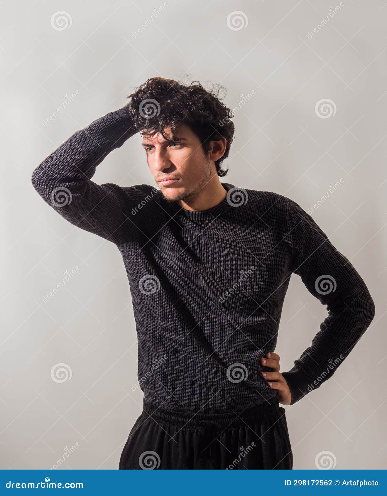 A Stylish Man Striking a Pose with His Hands on His Head Stock Photo ...