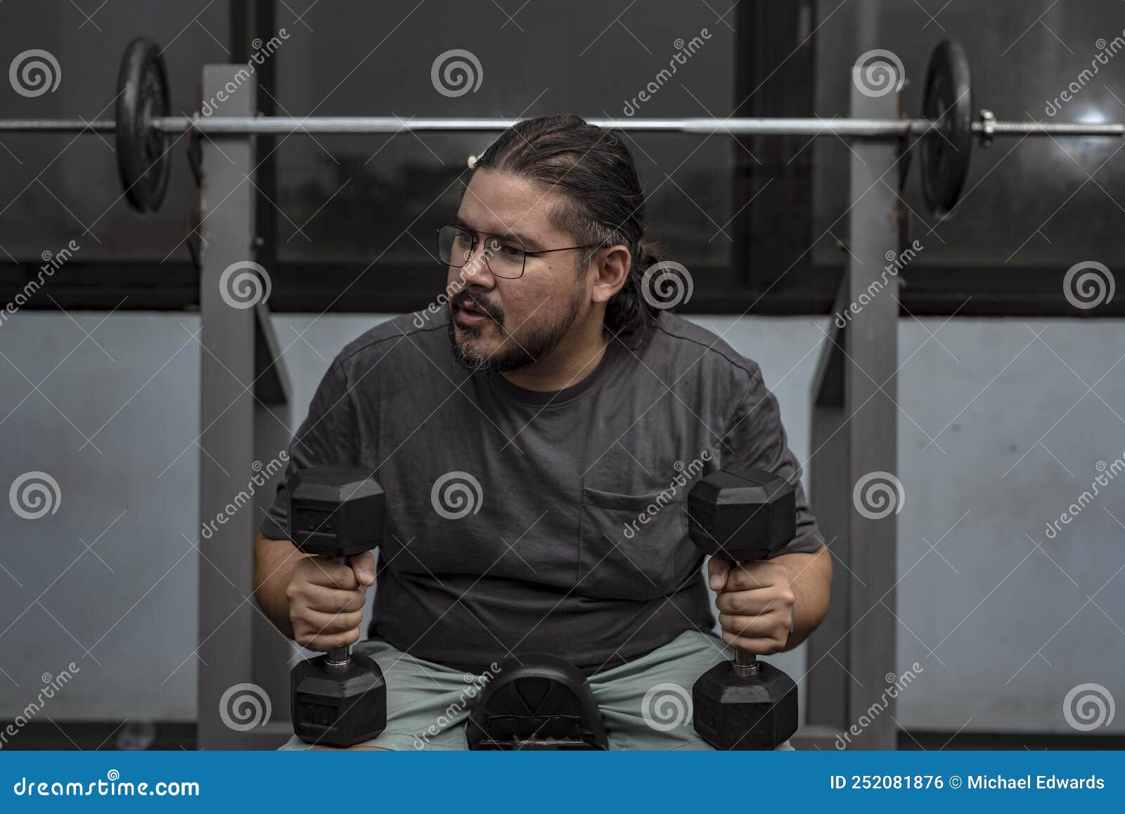 A Man in His Late 30s at the Gym Resting in between Sets. Contemplating ... A Man in His Late 30s at the Gym Resting in between Sets. Contemplating ...