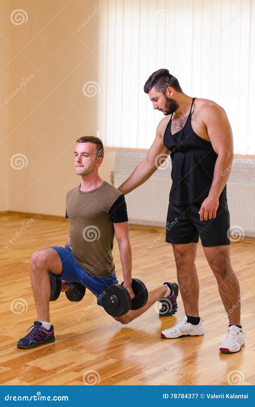 Man and His Personal Trainer Exercising with Dumbbells at the Gym ...