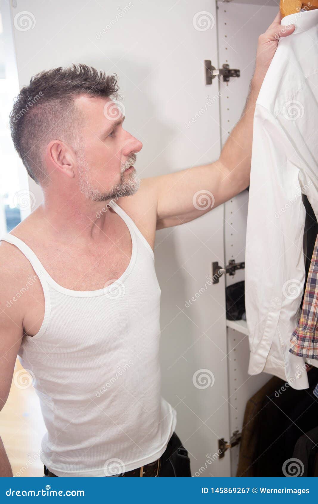 Man in His 50s Getting Dressed in Front of Closet Stock Image - Image ...