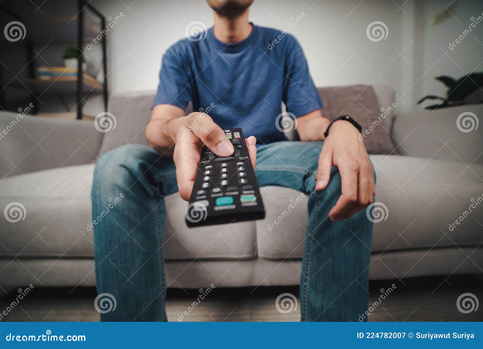 Man Hold and Press the TV Remote Controller Button Sitting on the Couch ...