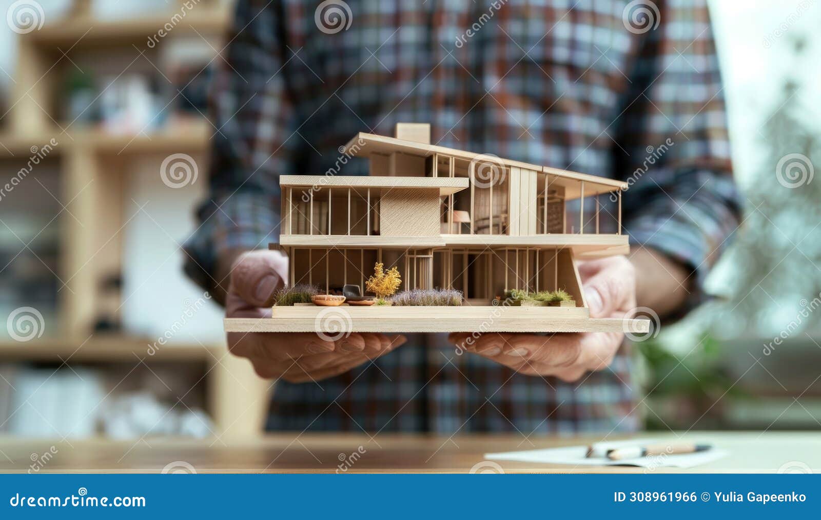 Man Holding an Architectural Model of House with House Plans Stock ...