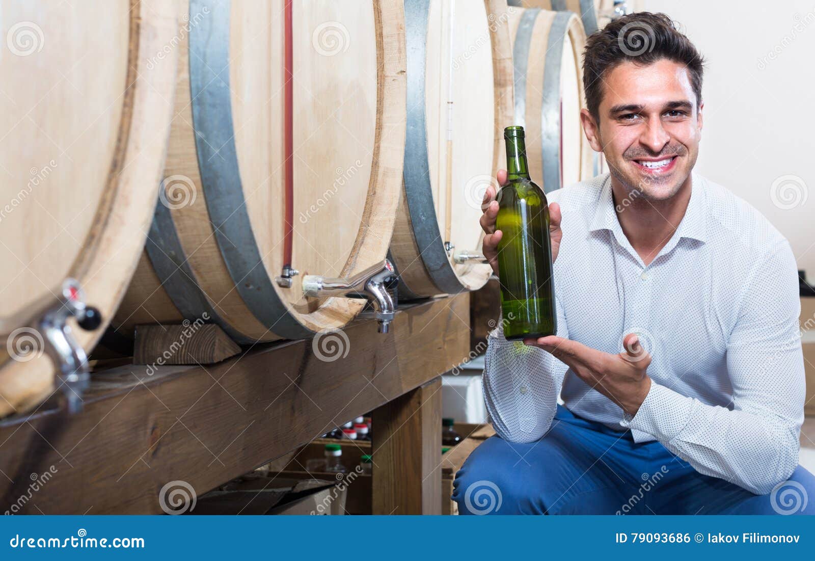 Man Holding Bottle of Wine in Cellar with Woods Stock Photo - Image of ...