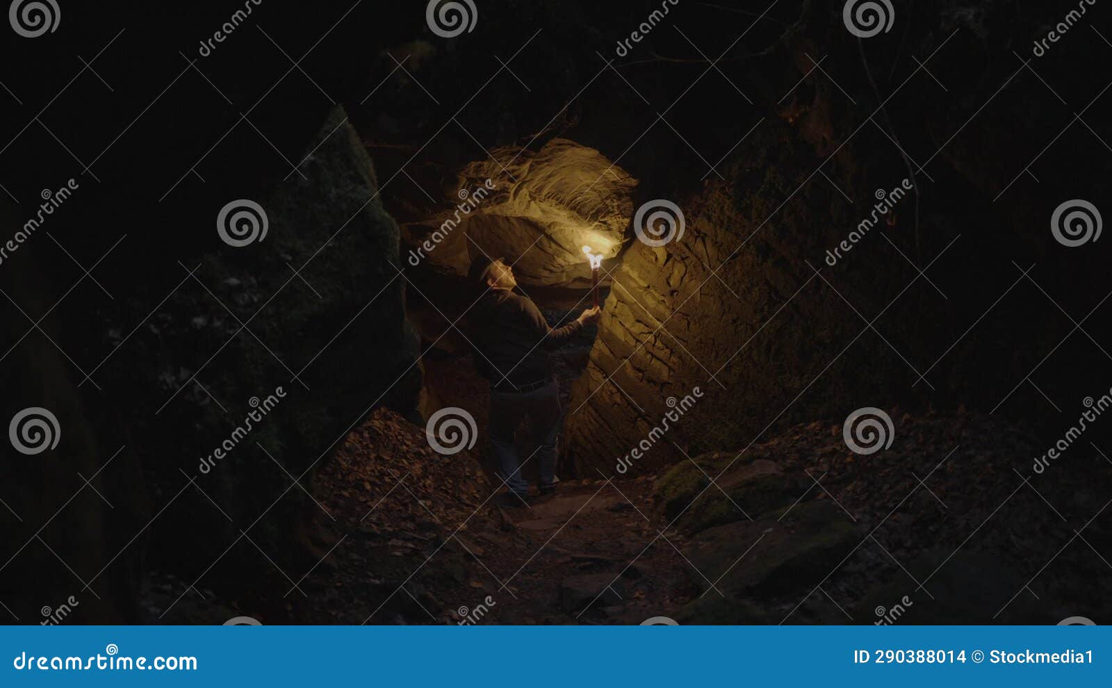 Man Holding a Burning Torchlight Exploring Forest Cave Landscape in ...