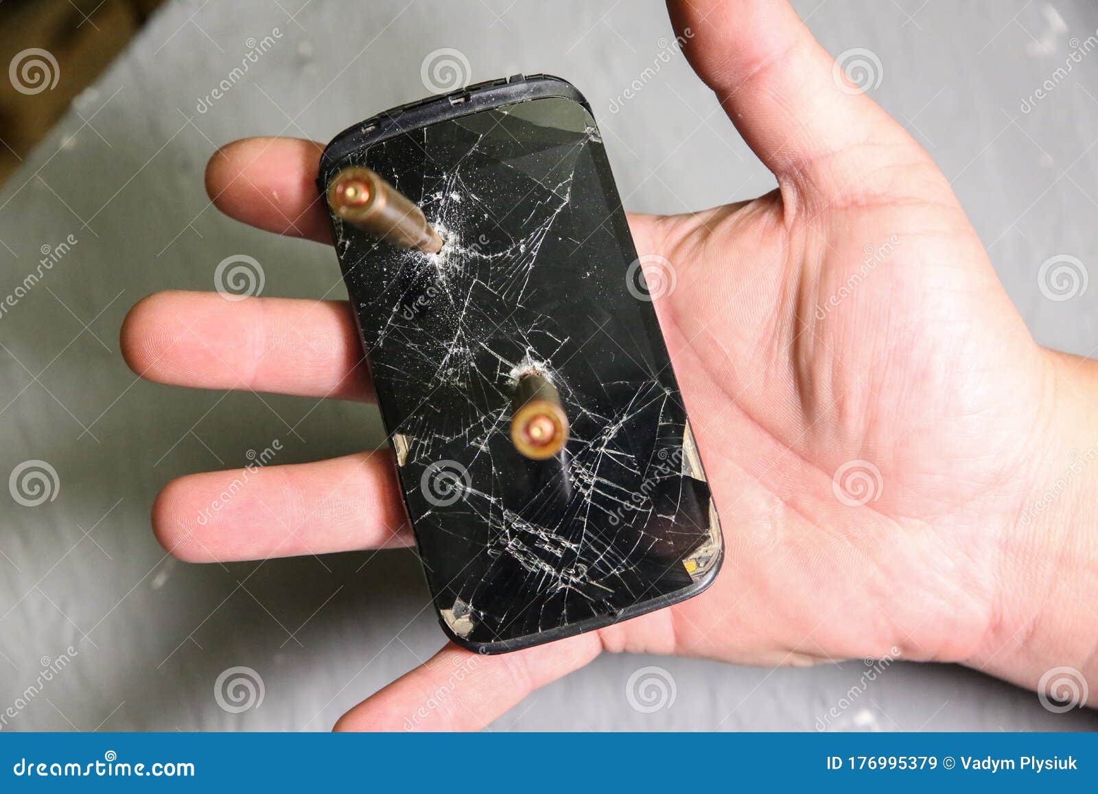 Man Holding Crashed Black Smartphone with a Bullet in Hand. Broken Lcd ...