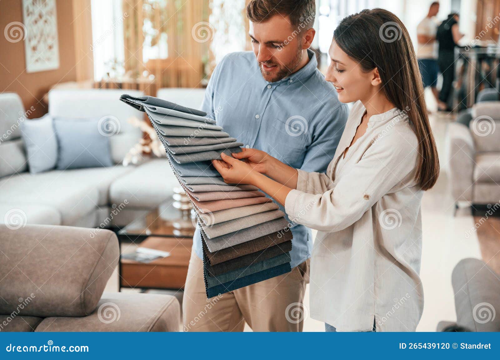 Man Holding Different Colored Materials To Choose from. Couple Looking ...