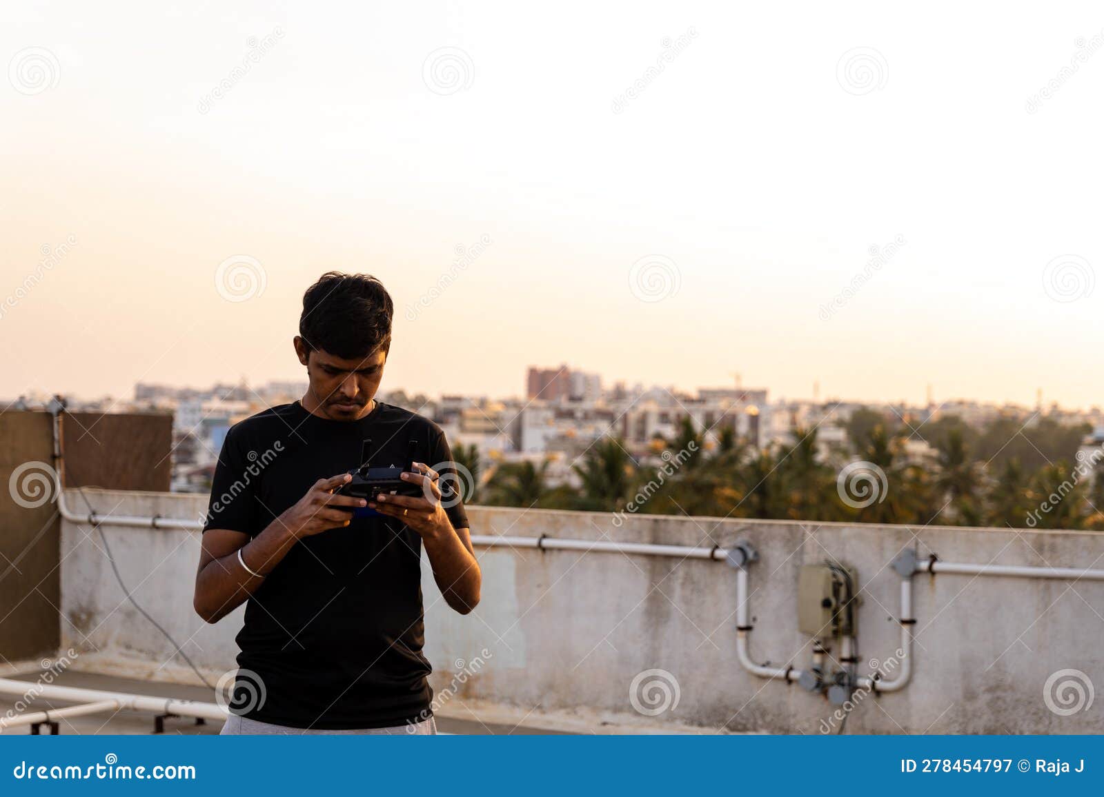 A Man Holding Drone Controller and Standing in Terrace, Stock Photo ...