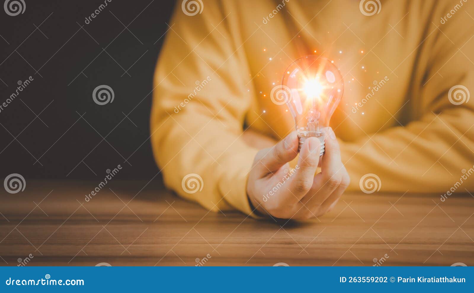 Man Holding a Glowing Abstract Light Bulb on a Wooden Table, Business ...
