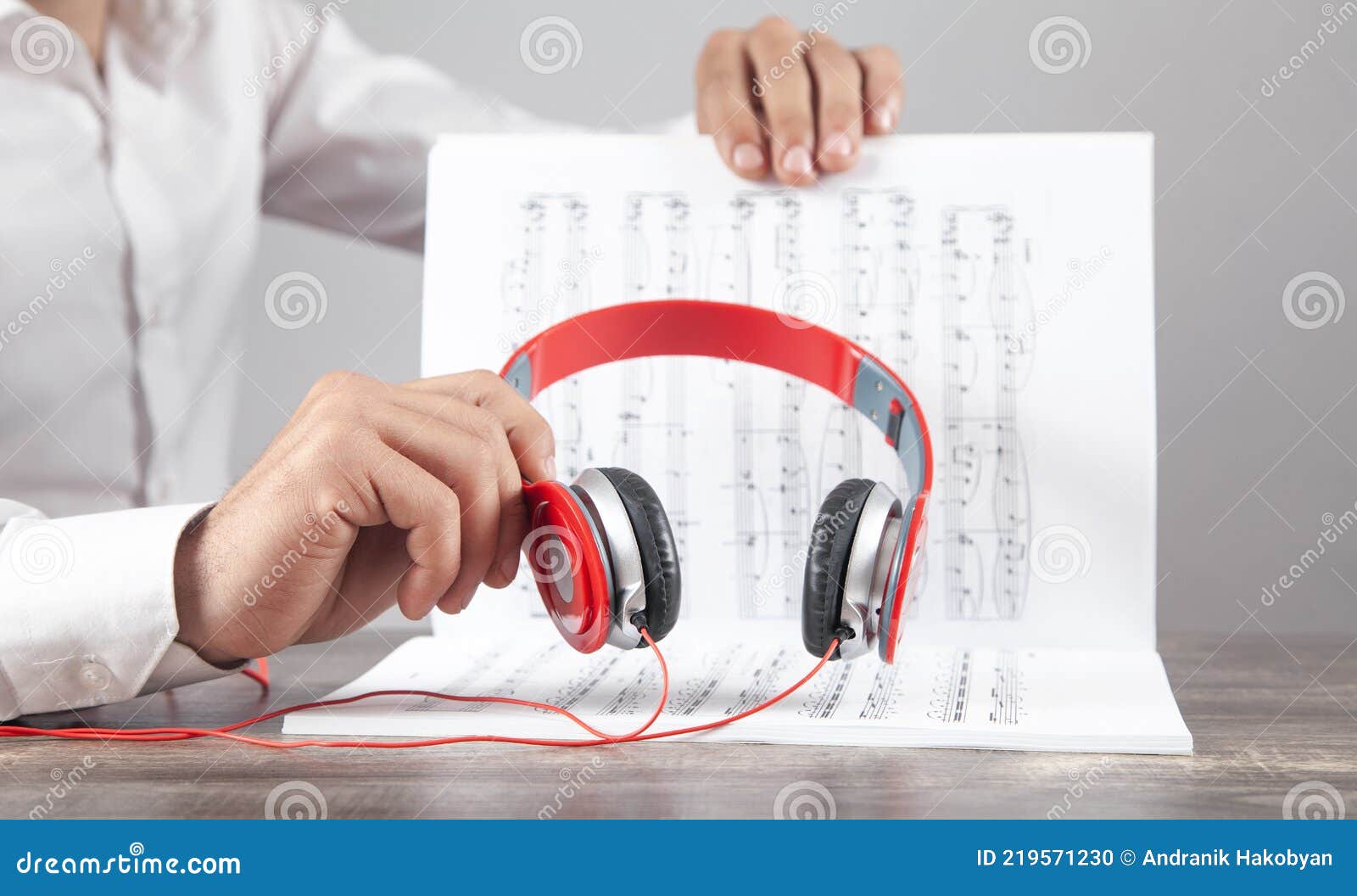Man Holding Headphones on Book of Music Note Stock Photo - Image of ...
