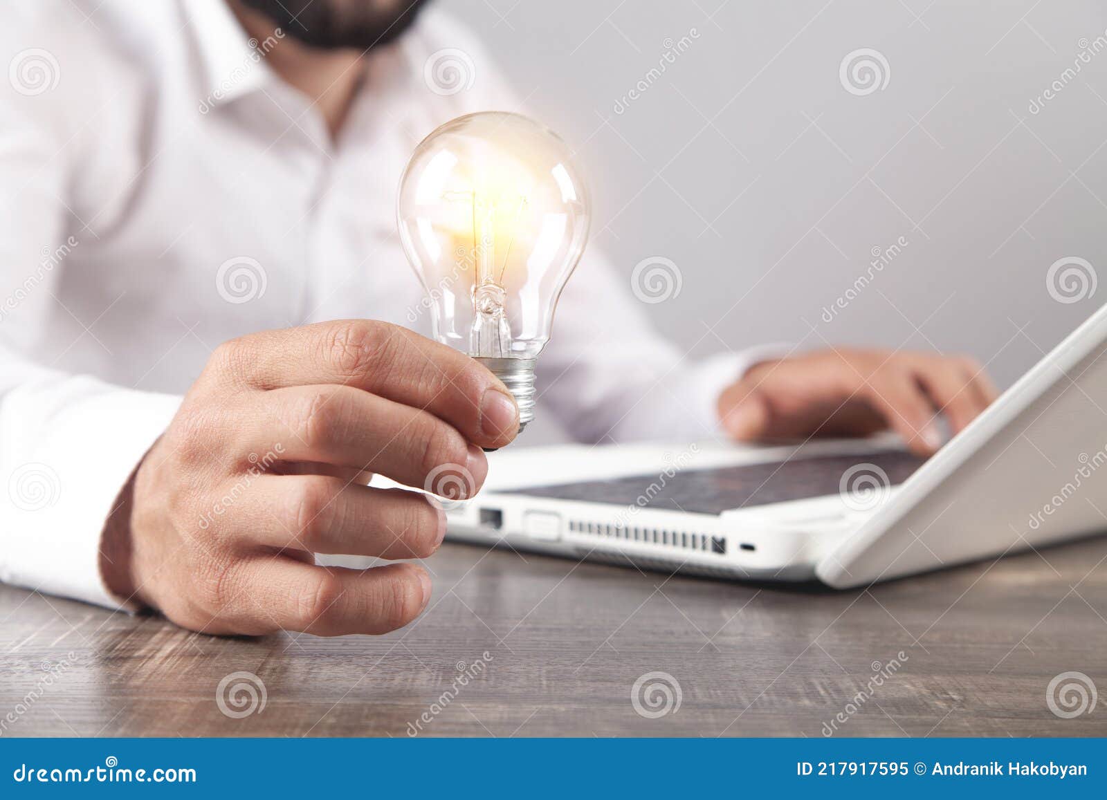 Man Holding Light Bulb and Using Laptop Computer Stock Image - Image of ...