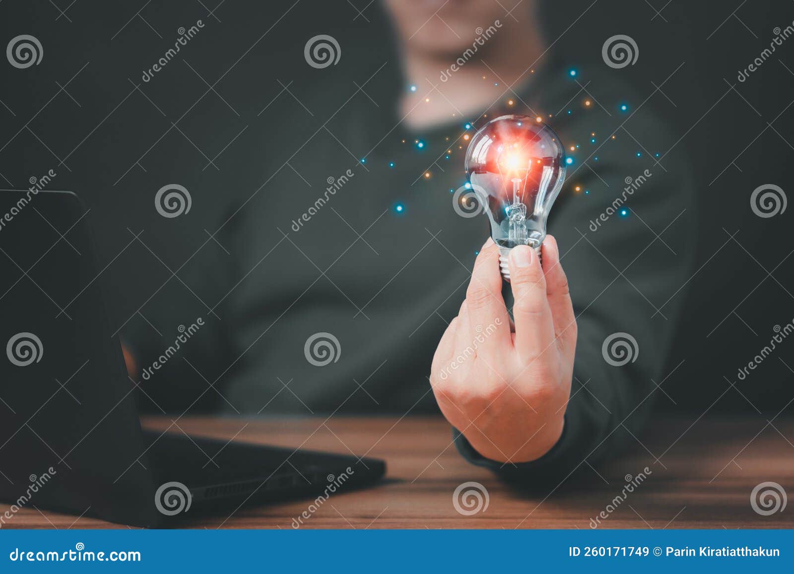 Man Holding a Light Bulb while Working on the Computer To Think and ...