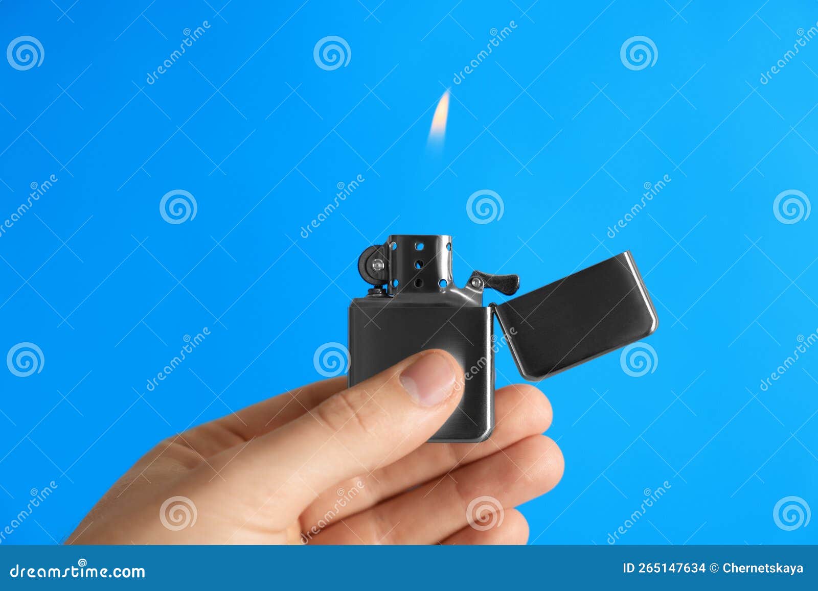 Man Holding Lighter with Burning Flame on Light Blue Background ...