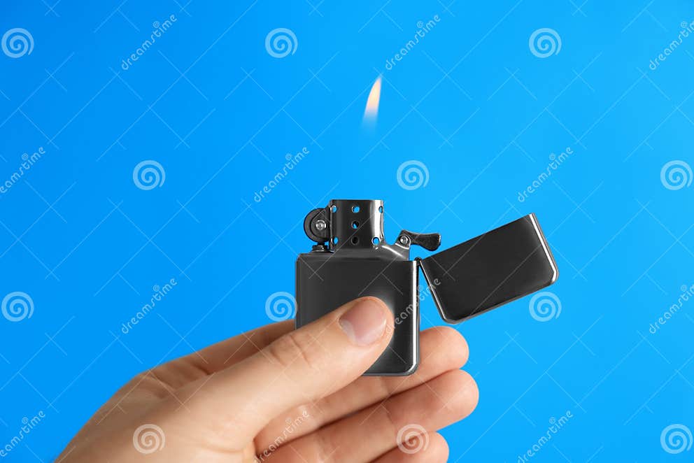 Man Holding Lighter with Burning Flame on Light Blue Background ...