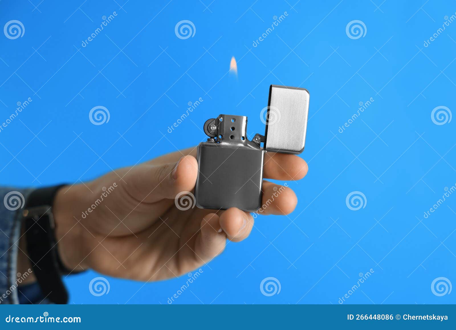 Man Holding Lighter with Burning Flame on Light Blue Background ...