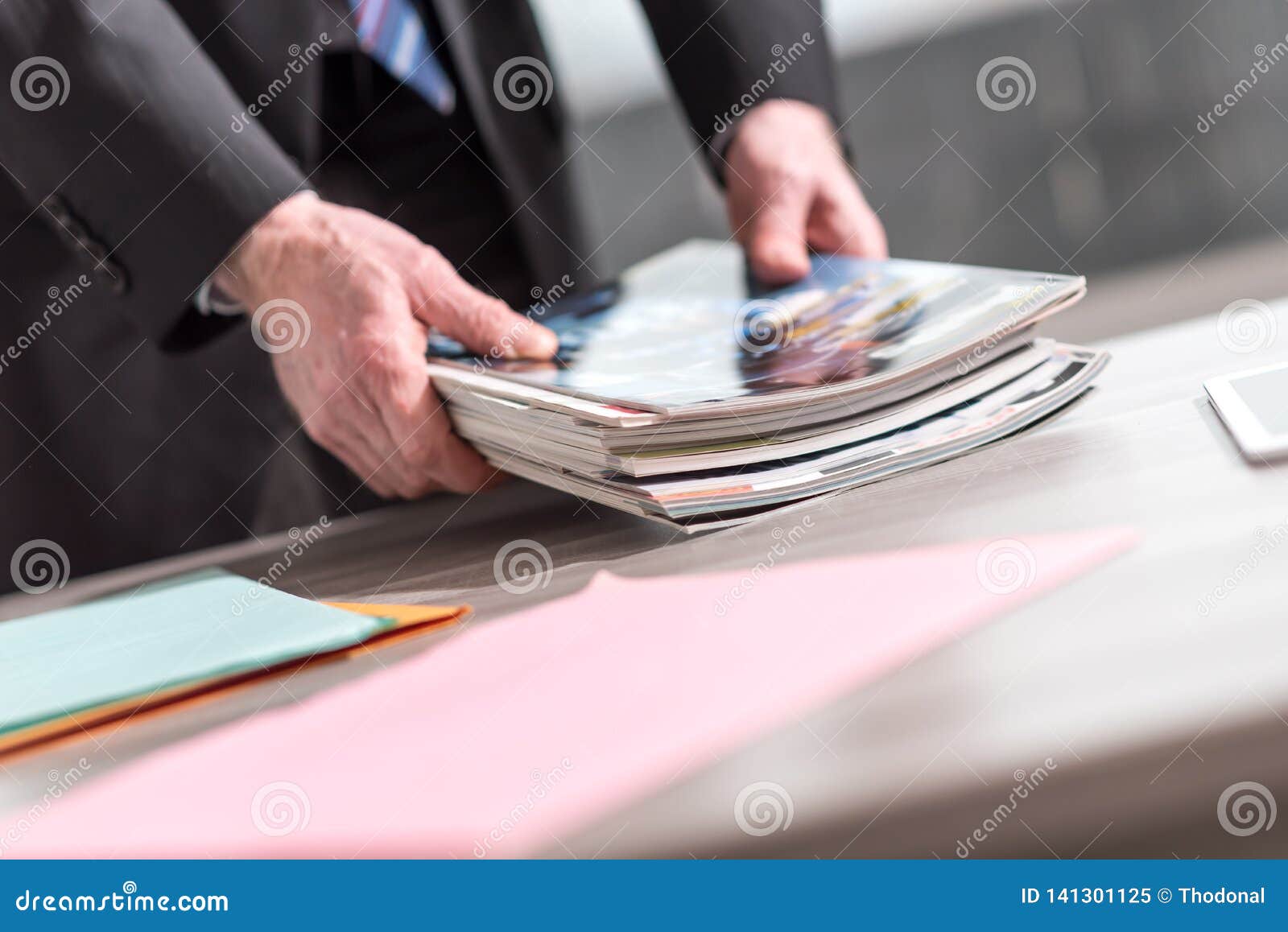 Man holding magazines stock image. Image of newspaper - 141301125