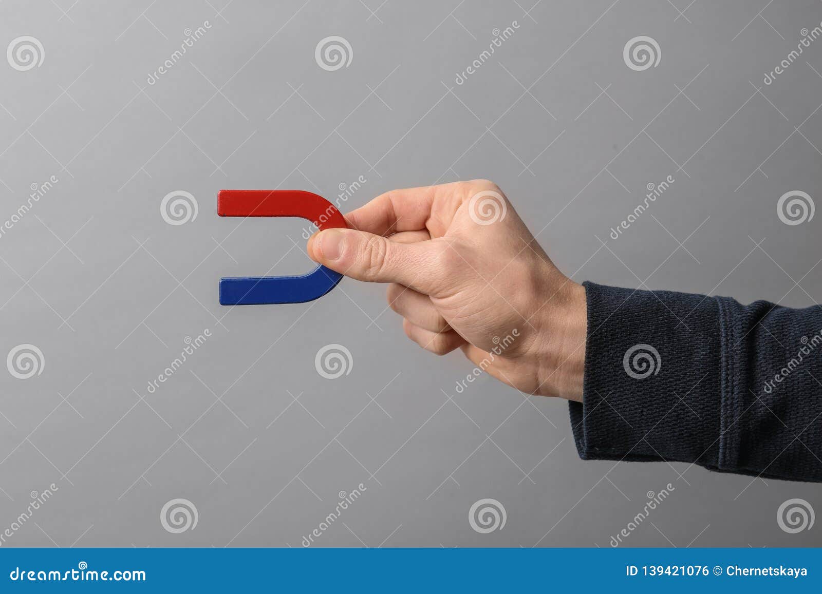 Man Holding Magnet on Grey Background Stock Photo - Image of audience ...