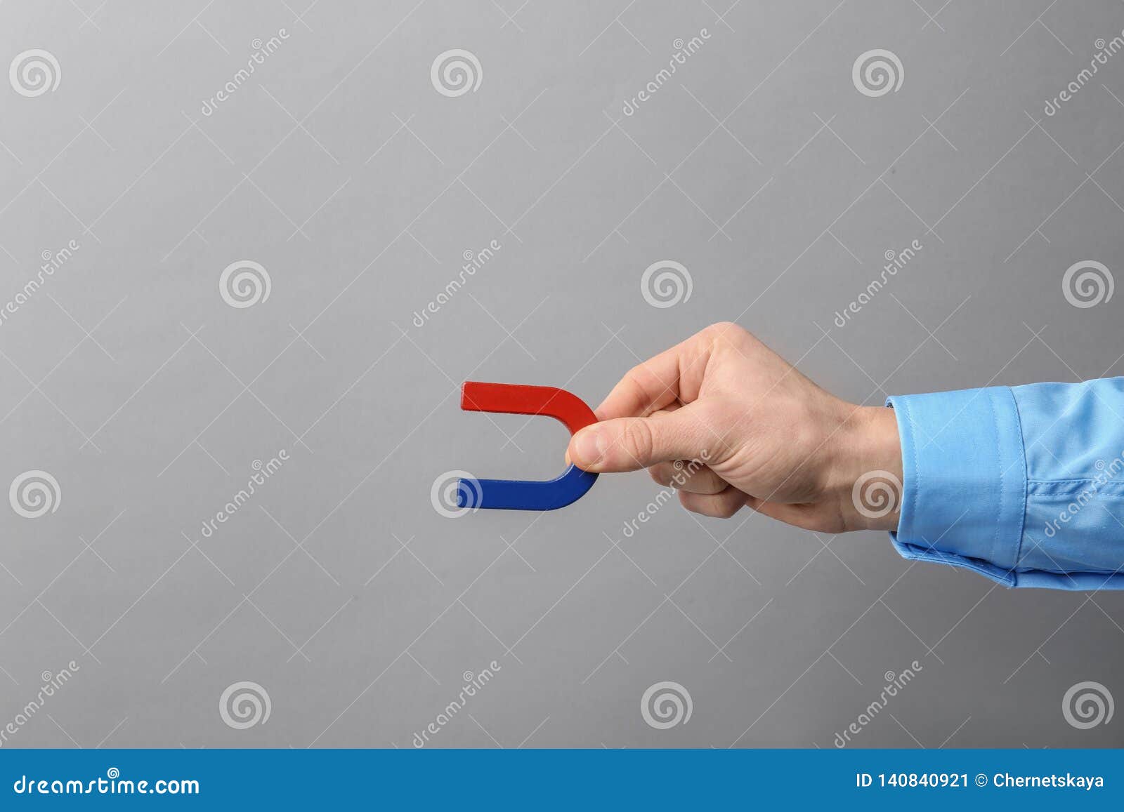 Man Holding Magnet on Grey Background. Space for Text Stock Image ...