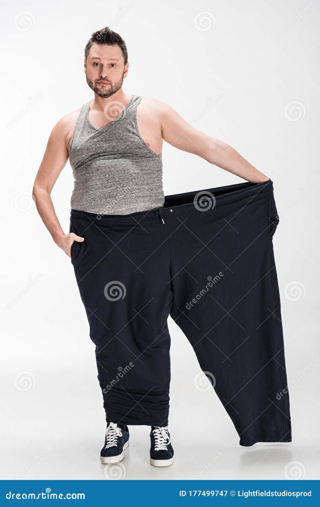 Man Holding Oversize Pants after Weight Loss and Looking at Camera on ...