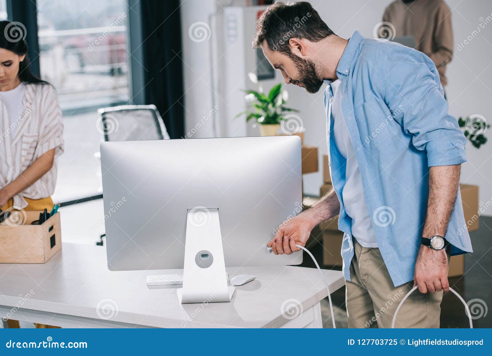 Man Holding Plug from Desktop Computer while Relocating with Coworkers ...