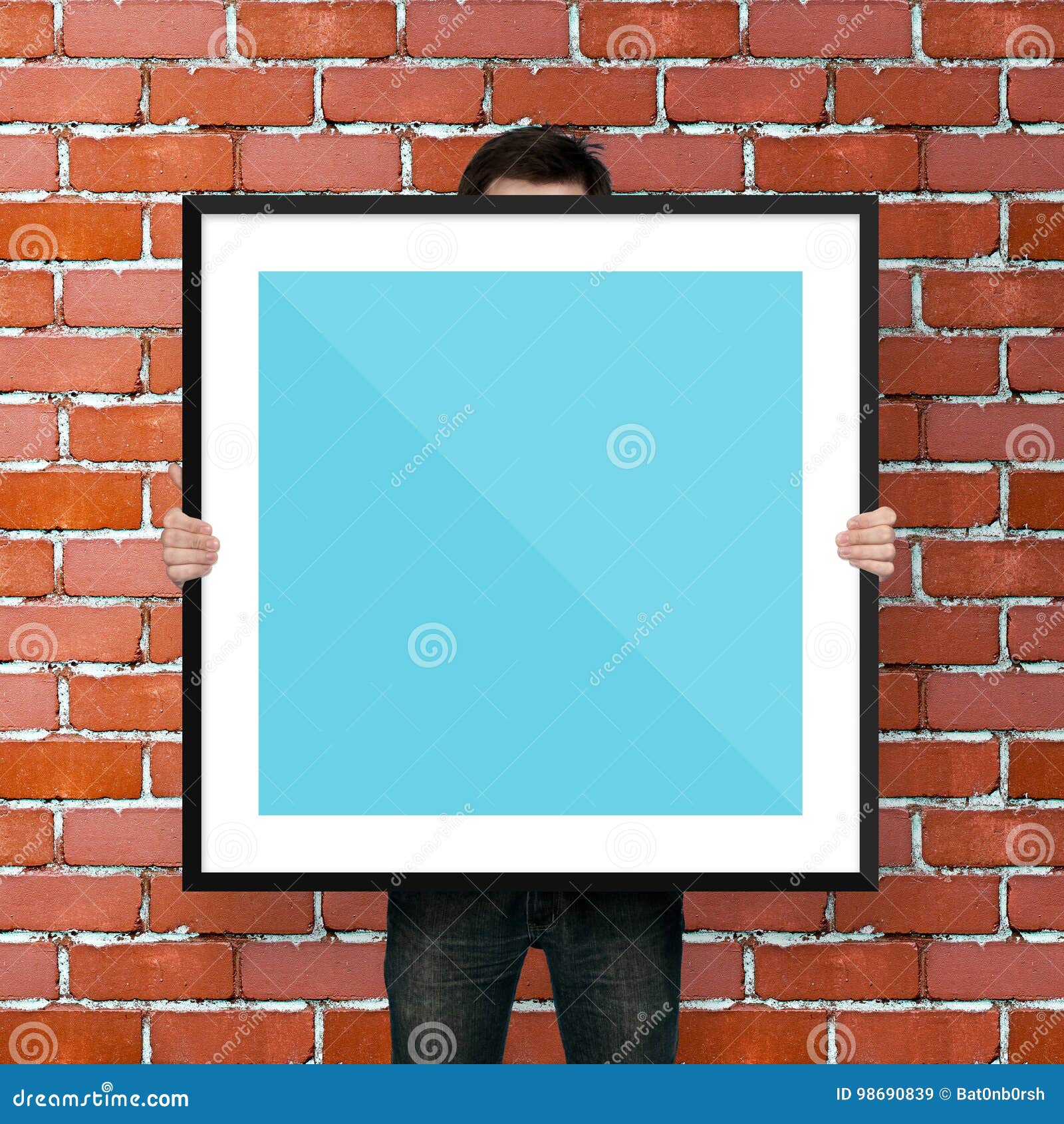 Man Holding Poster Mockup Template with Frame on Brick Background Stock ...