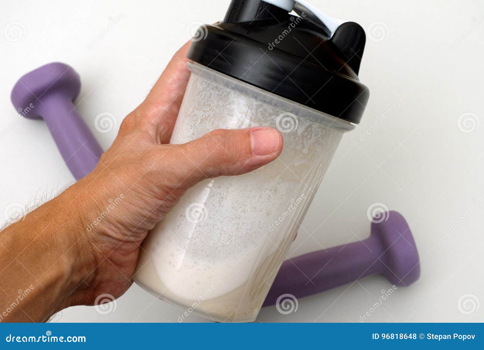 Man Holding Protein Shake in His Hand Above Dumbbells Stock Photo ...