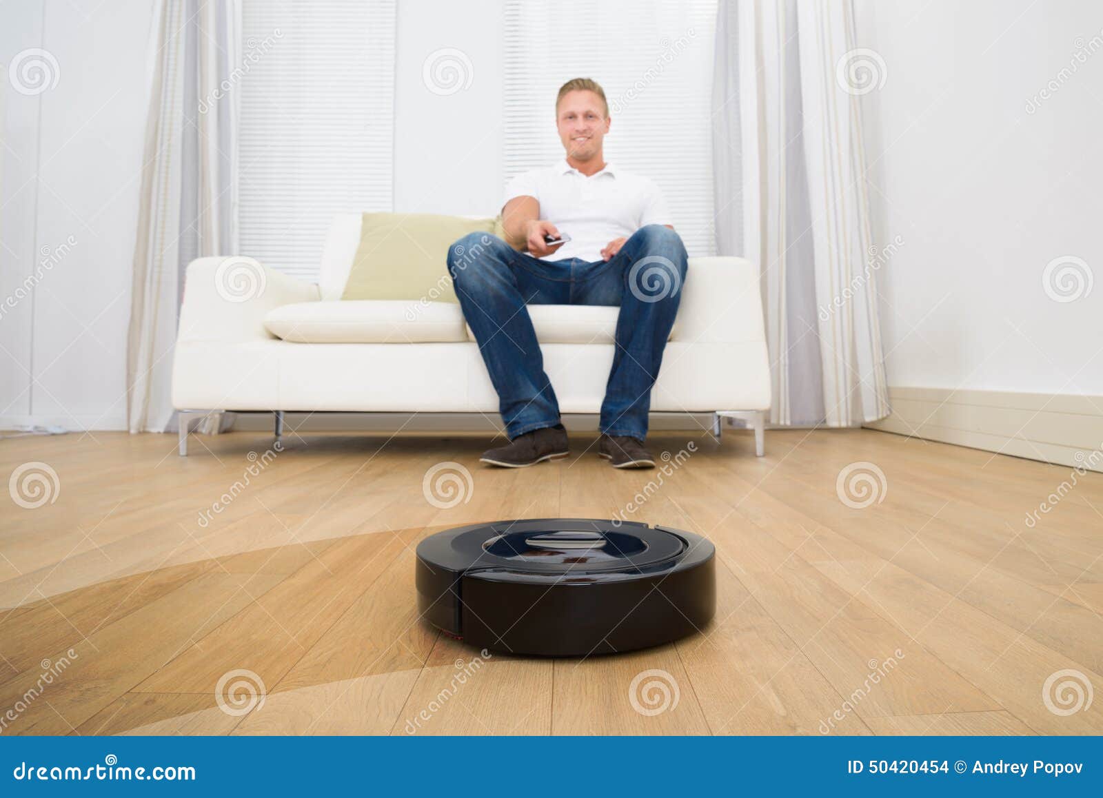 Man Holding Remote Control of Robotic Vacuum Cleaner Stock Photo ...