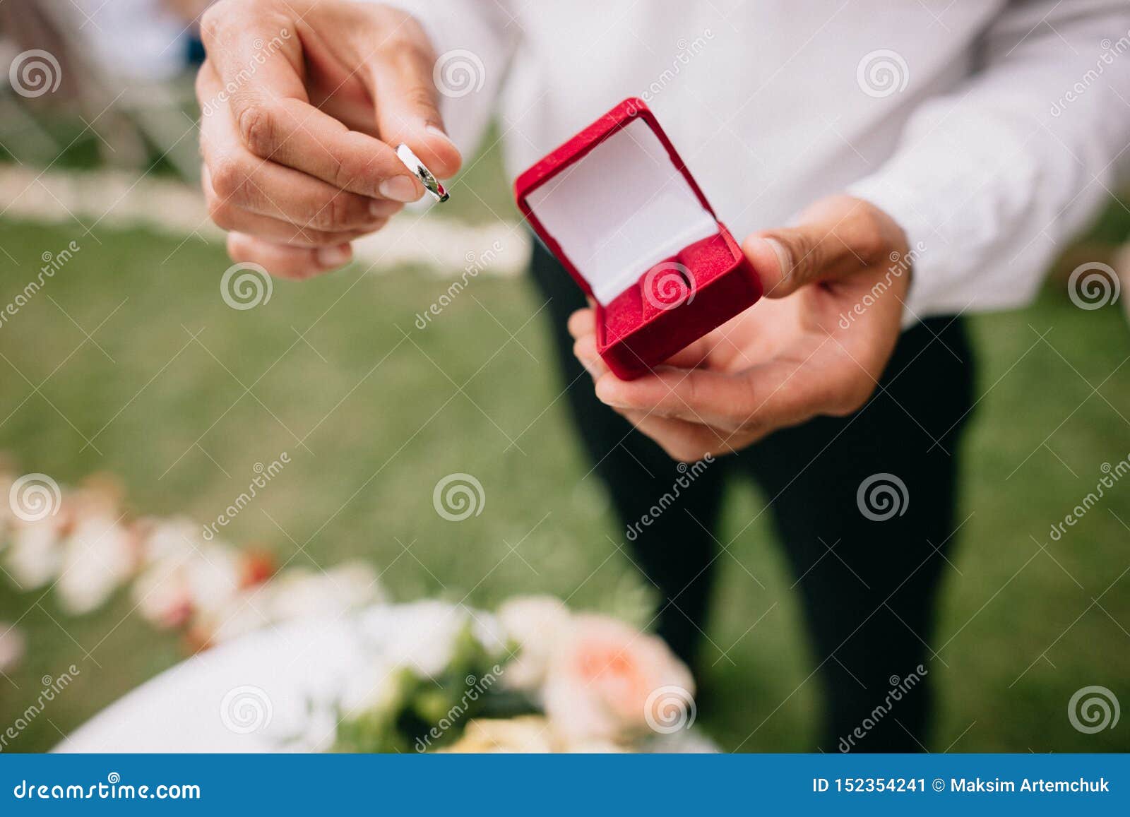 Man is Holding a Ring in His Right Hand and a Red Ring Box in His Left ...