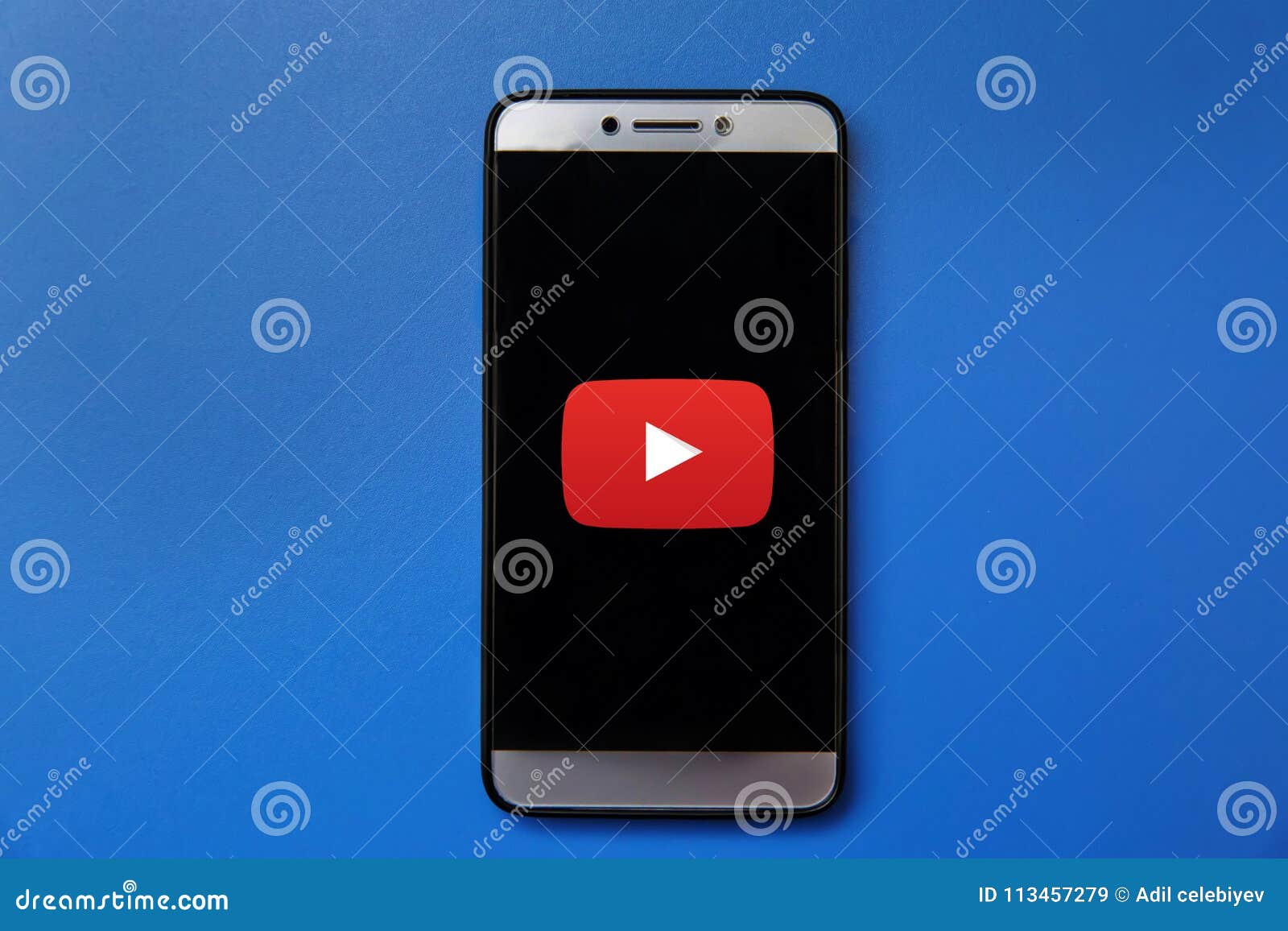 Youtube Logo on Smartphone Screen on Blue Background. Man Holding ...