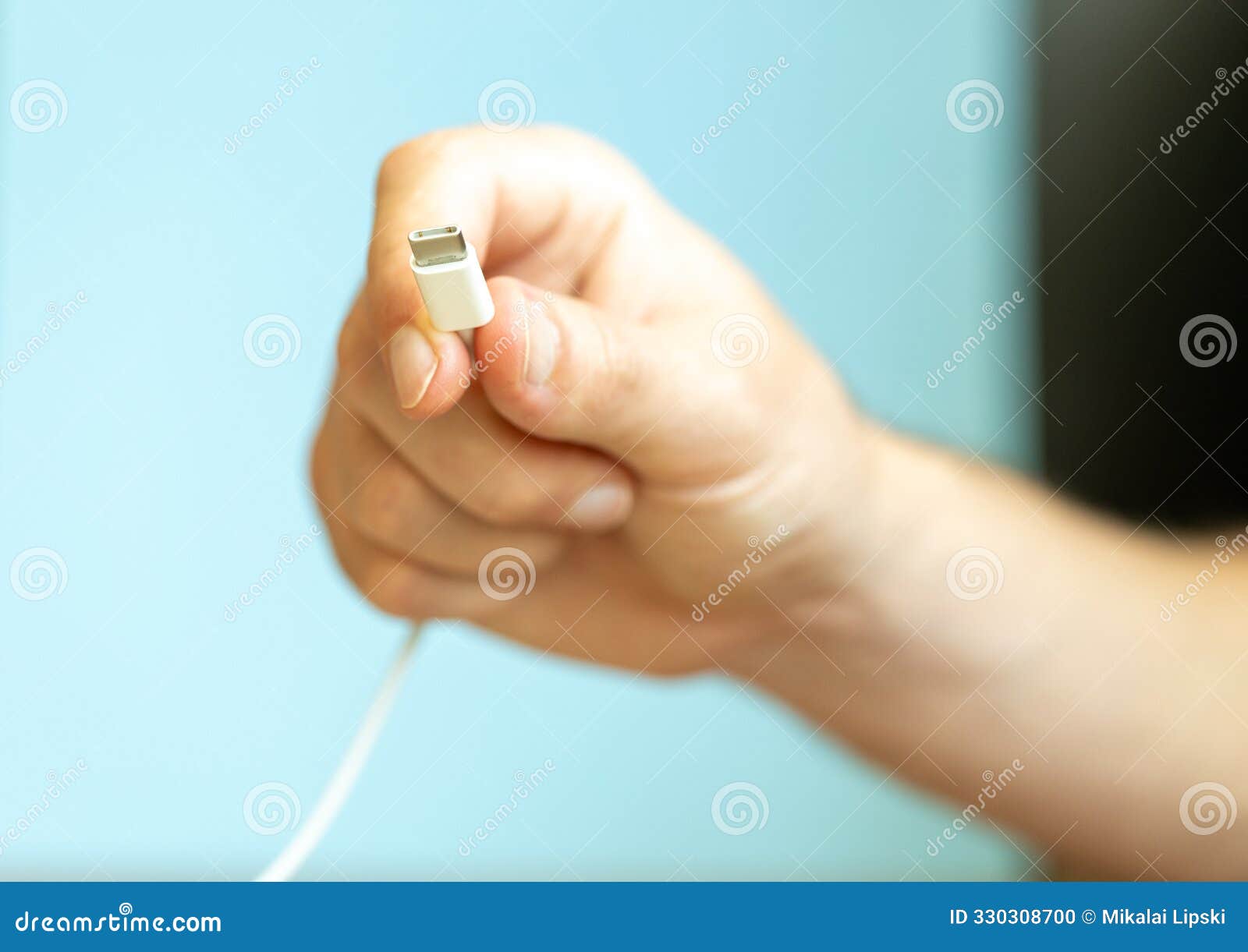 Man Holding USB Cable in Hand on Blue Background, Technology Concept ...