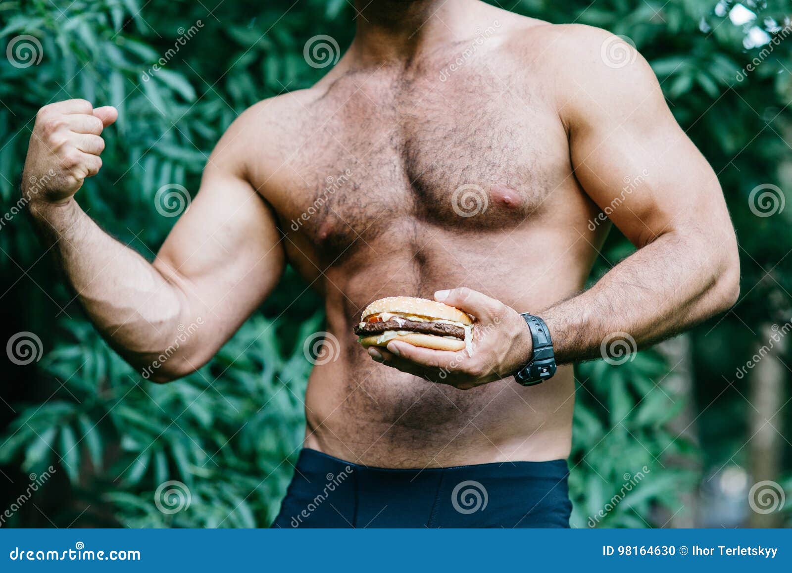 A Man Holds a Burger and Shows a Biceps Stock Photo - Image of burger ...