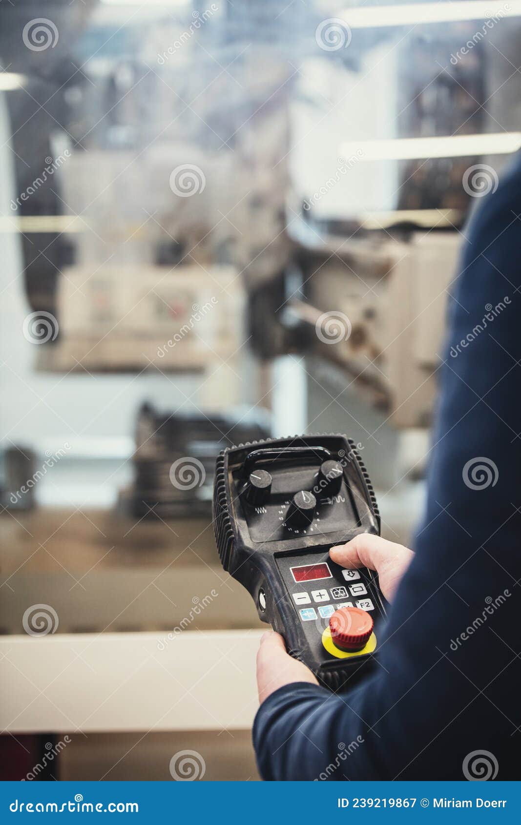 A Man Holds the Control Panel of a Cnc Machine in a Workshop Stock ...