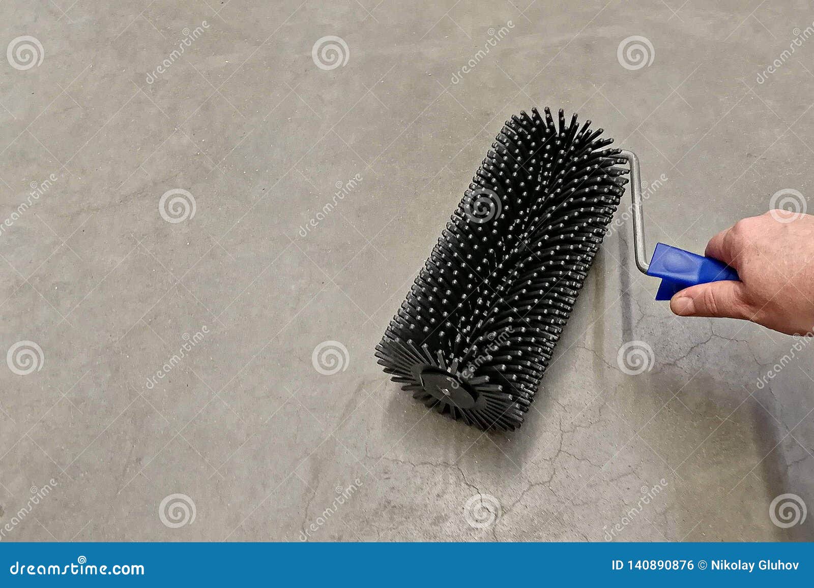 A Man Holds in His Hand a Construction Roller-building Tool Stock Photo ...