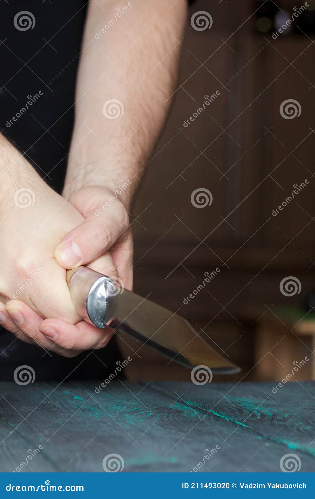 A Man Holds a Knife Above the Table Surface with Both Hands. Close-up ...
