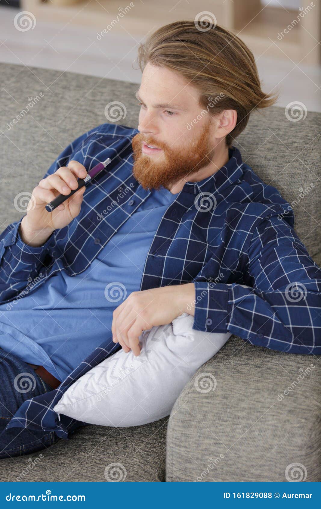 Man at Home on Sofa Smoking Electronic Cigarette Stock Photo - Image of ...
