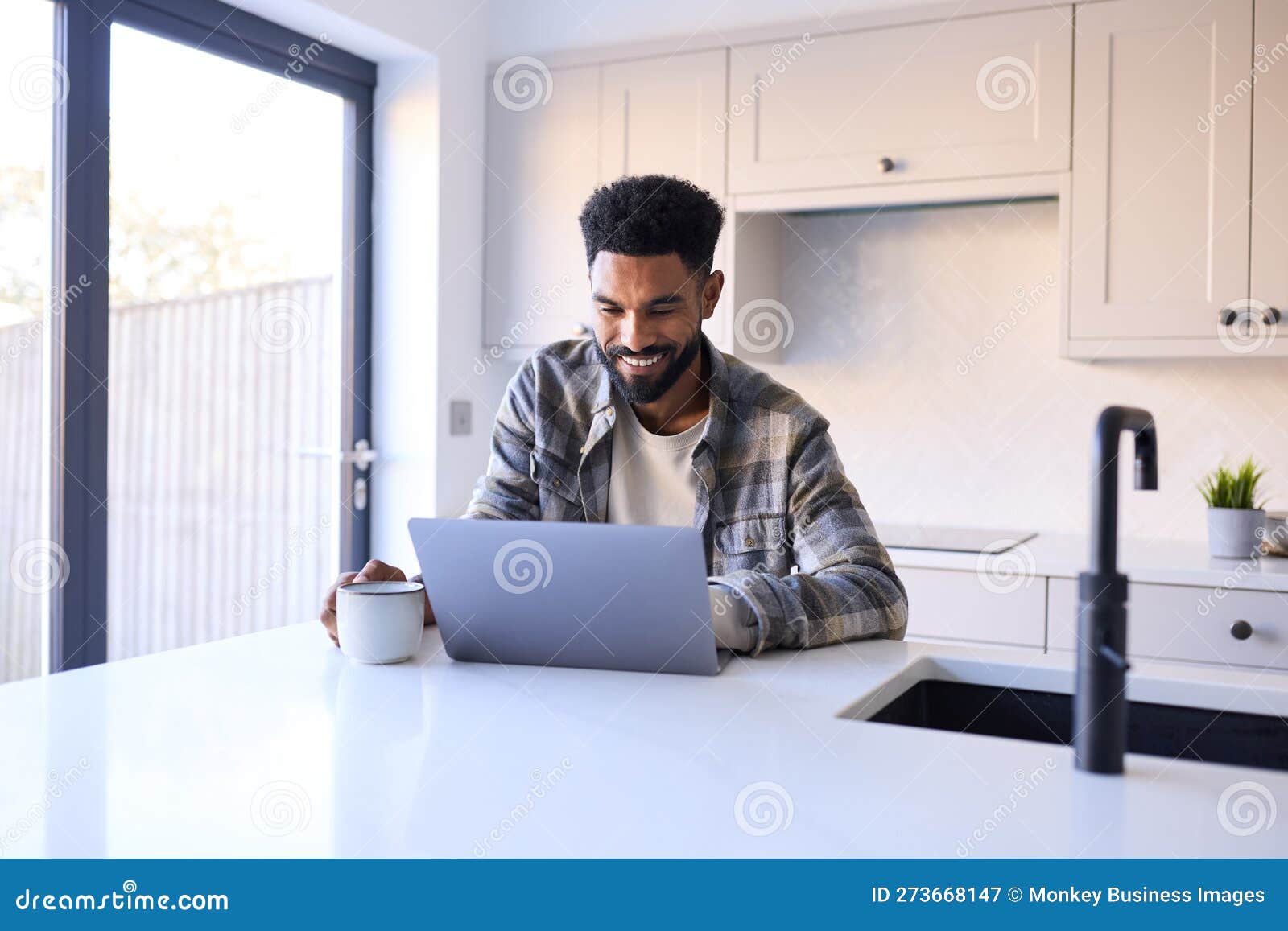 Man at Home Working on Laptop on Counter in Kitchen Stock Image - Image ...