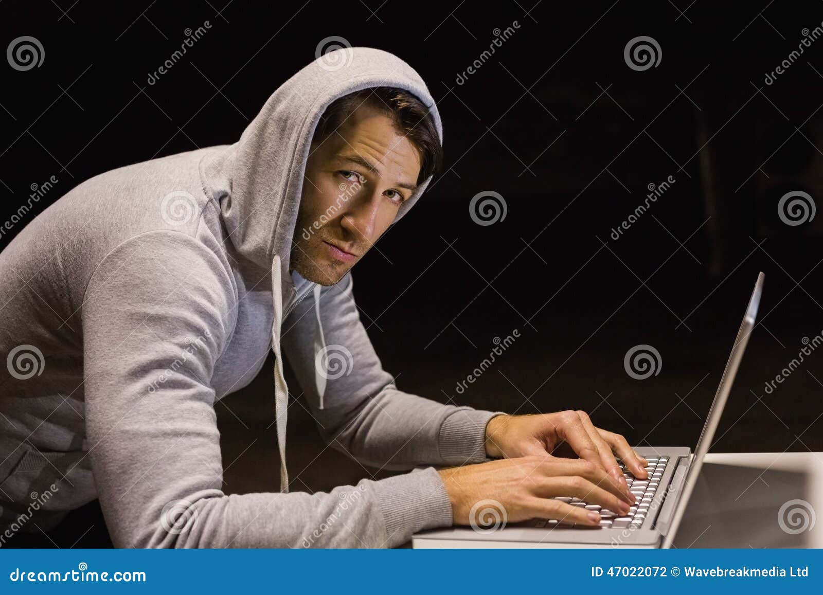 Man in Hood Jacket Hacking a Laptop while Looking at Camera Stock Photo ...
