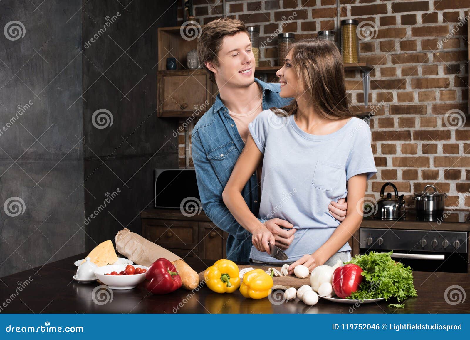 Man Hugging Girlfriend while she Cooking Dinner in Kitchen Stock Photo ...