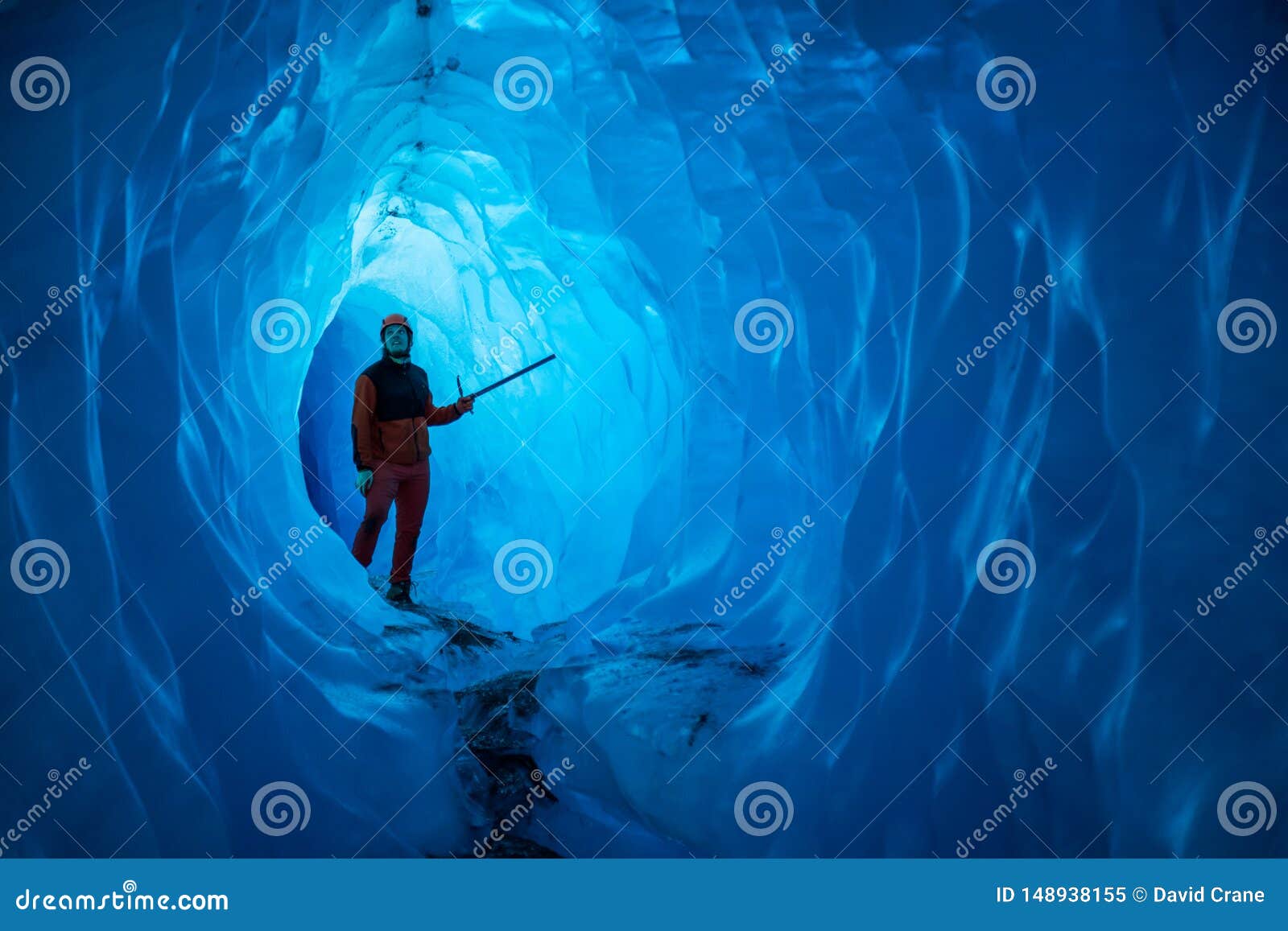 Man Inside a Melting Glacier Ice Cave. Cut by Water from the Melting ...