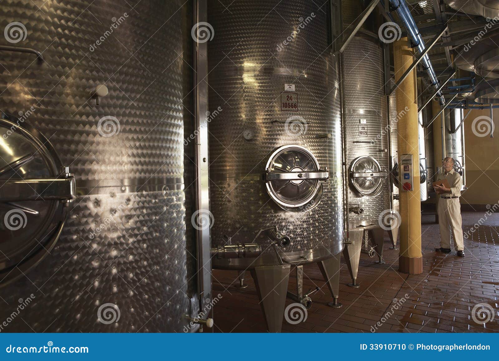 Man Inspecting Wine Vats Inside Winery Stock Photo - Image of metallic ...